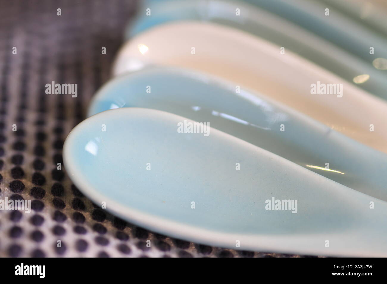 White and blue ceramic spoons under close up lens Stock Photo - Alamy