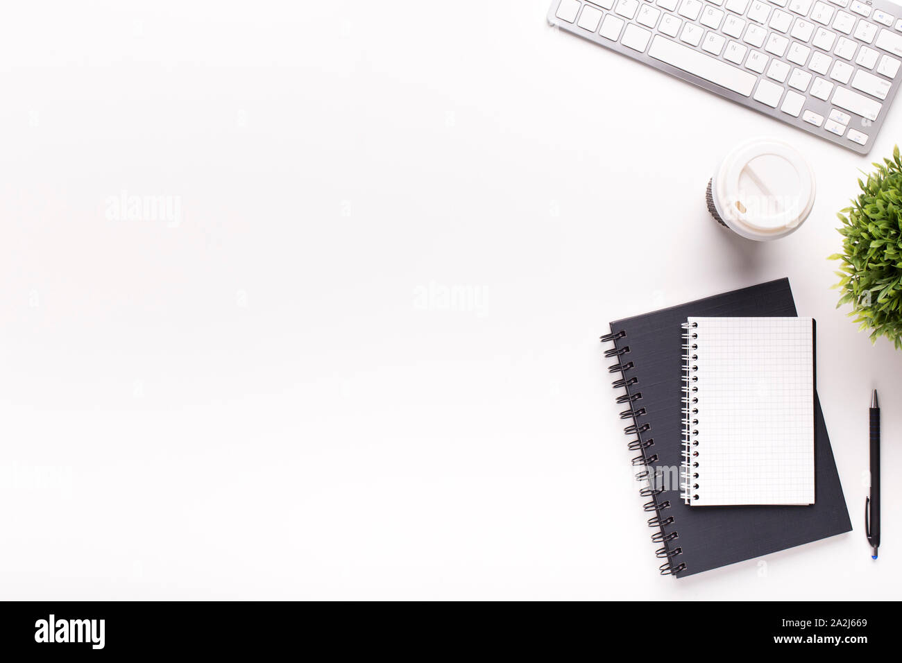 Black and white notepads, keyboard and plant on office table Stock ...
