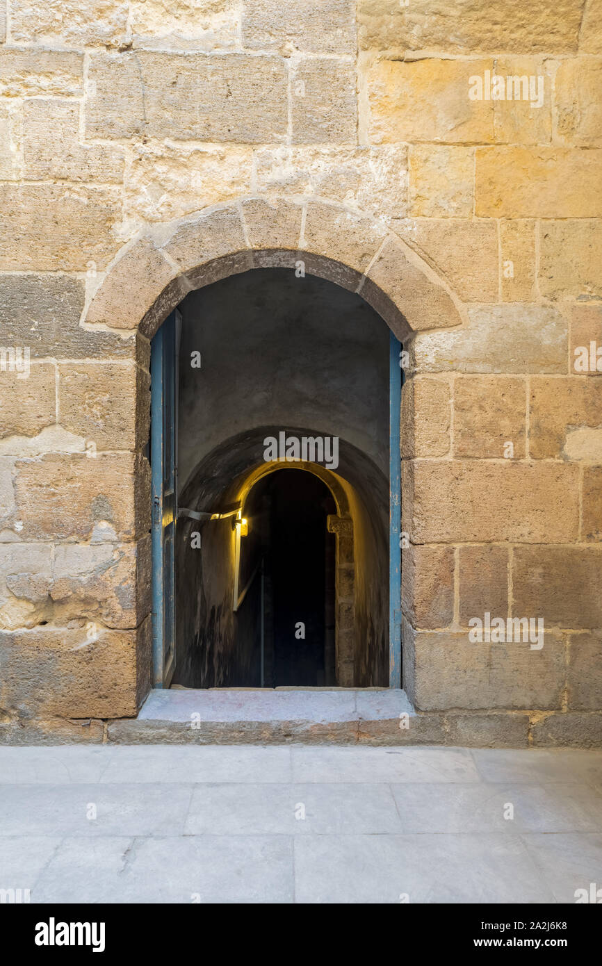 Stone bricks wall with open wooden door leading to the staircase of ...