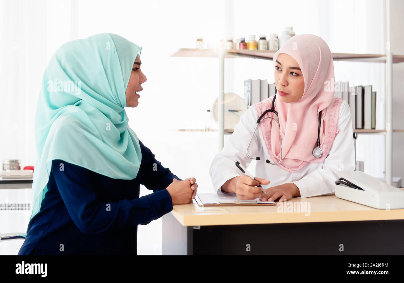 A young beautiful Muslim doctor wearing a stethoscope asking the ...