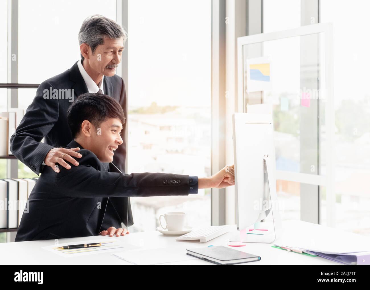 The young businessman smiling and checking the point to the screen. He ...