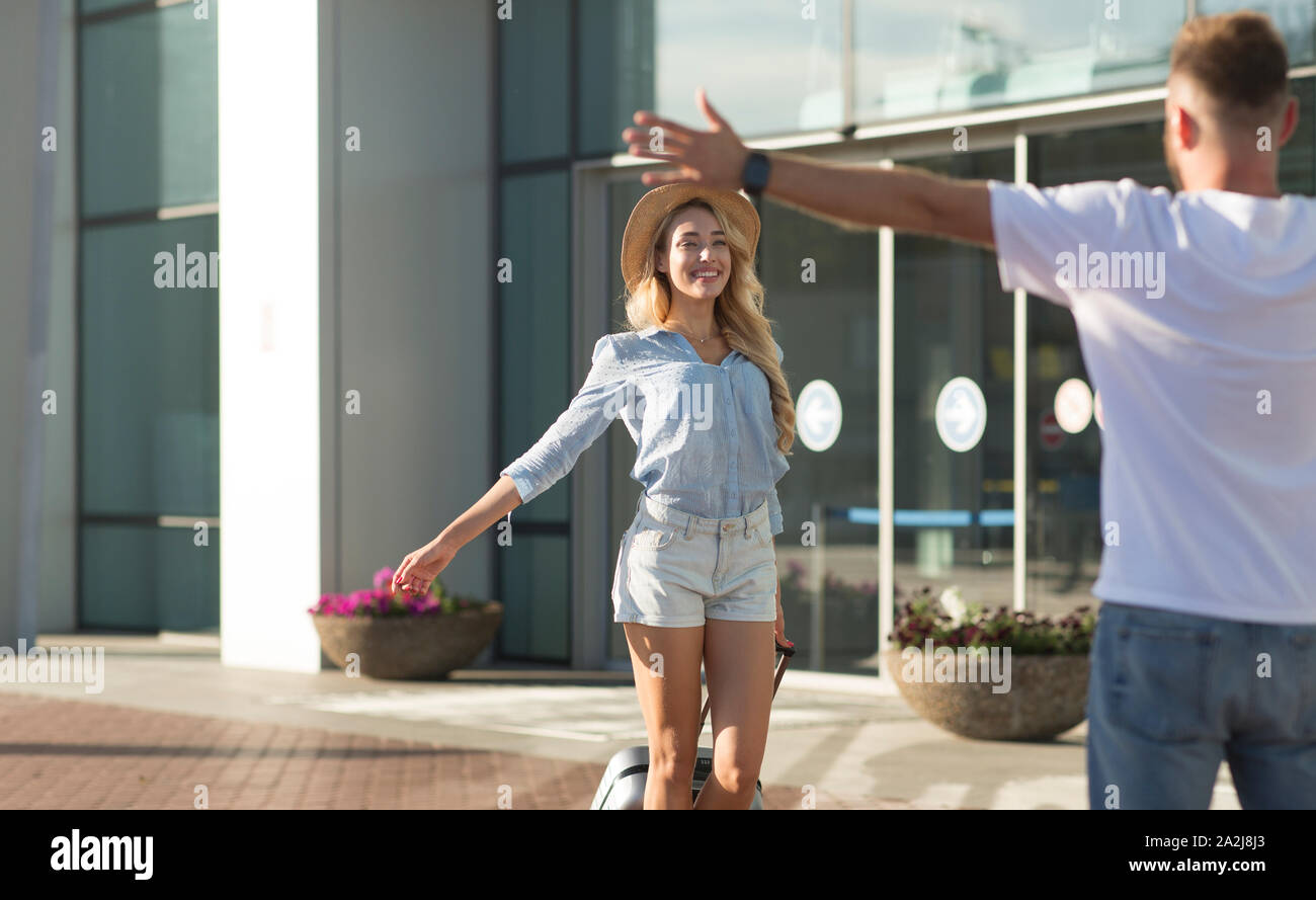 Boyfriend picking up his girlfriend near airport building Stock Photo ...