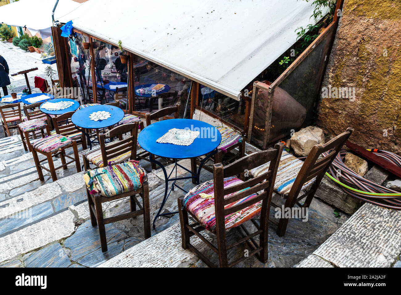 Chairs and tables of a bar on the street stairs in the Plaka ...