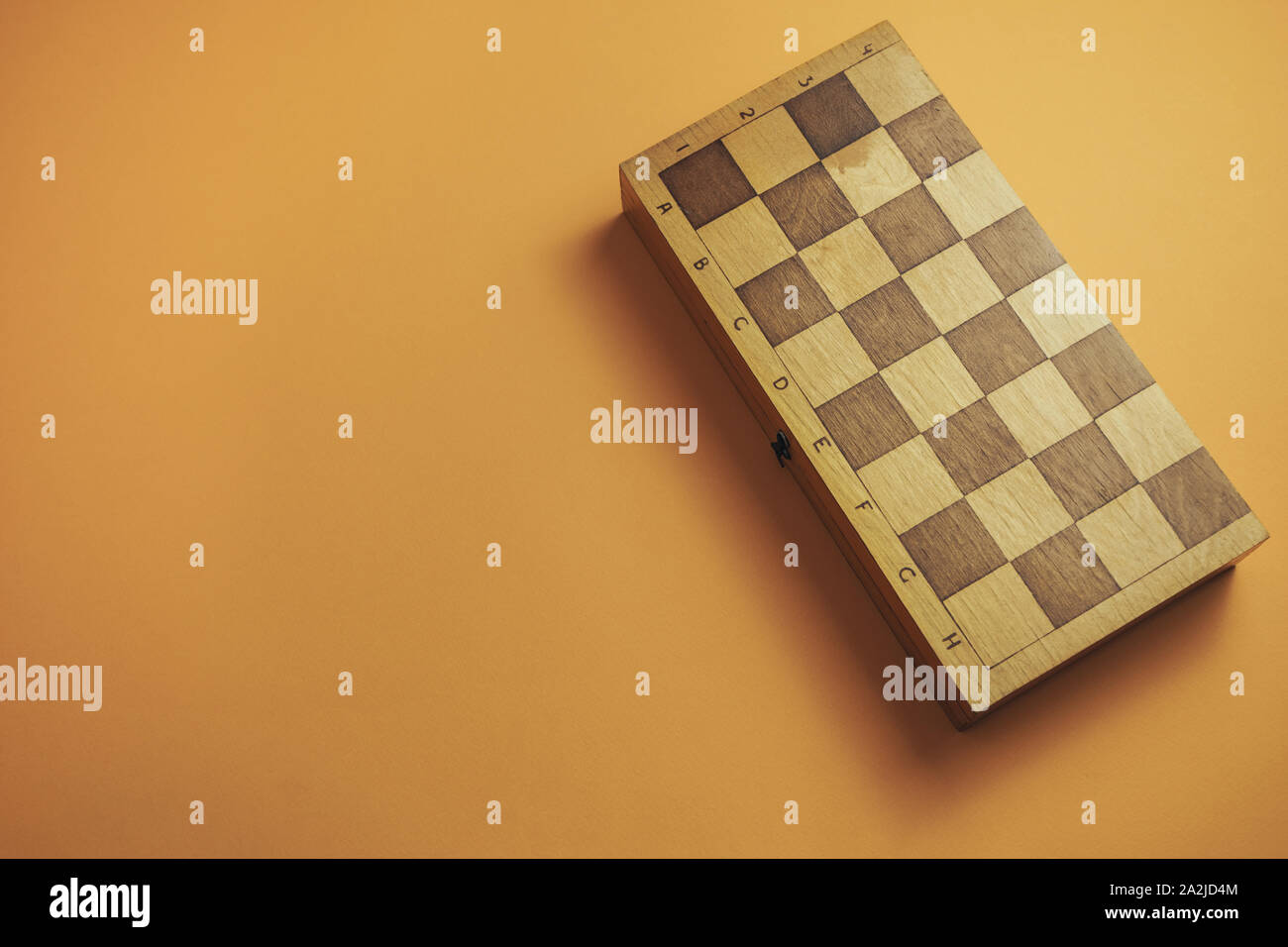 Beautiful old chess board on a orange background Stock Photo - Alamy