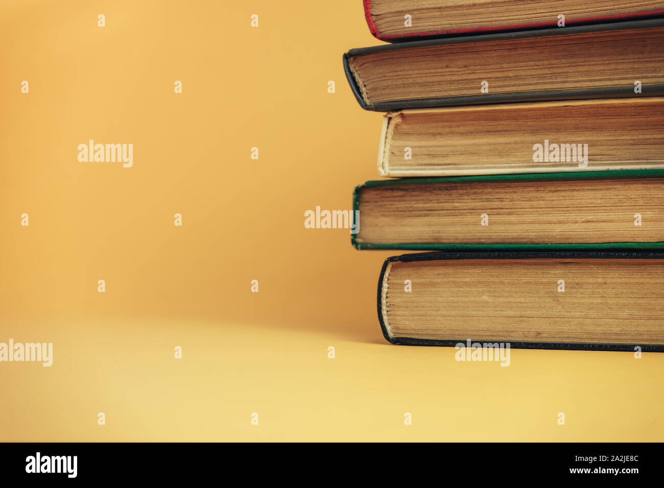 Beautiful old books on a orange background Stock Photo - Alamy