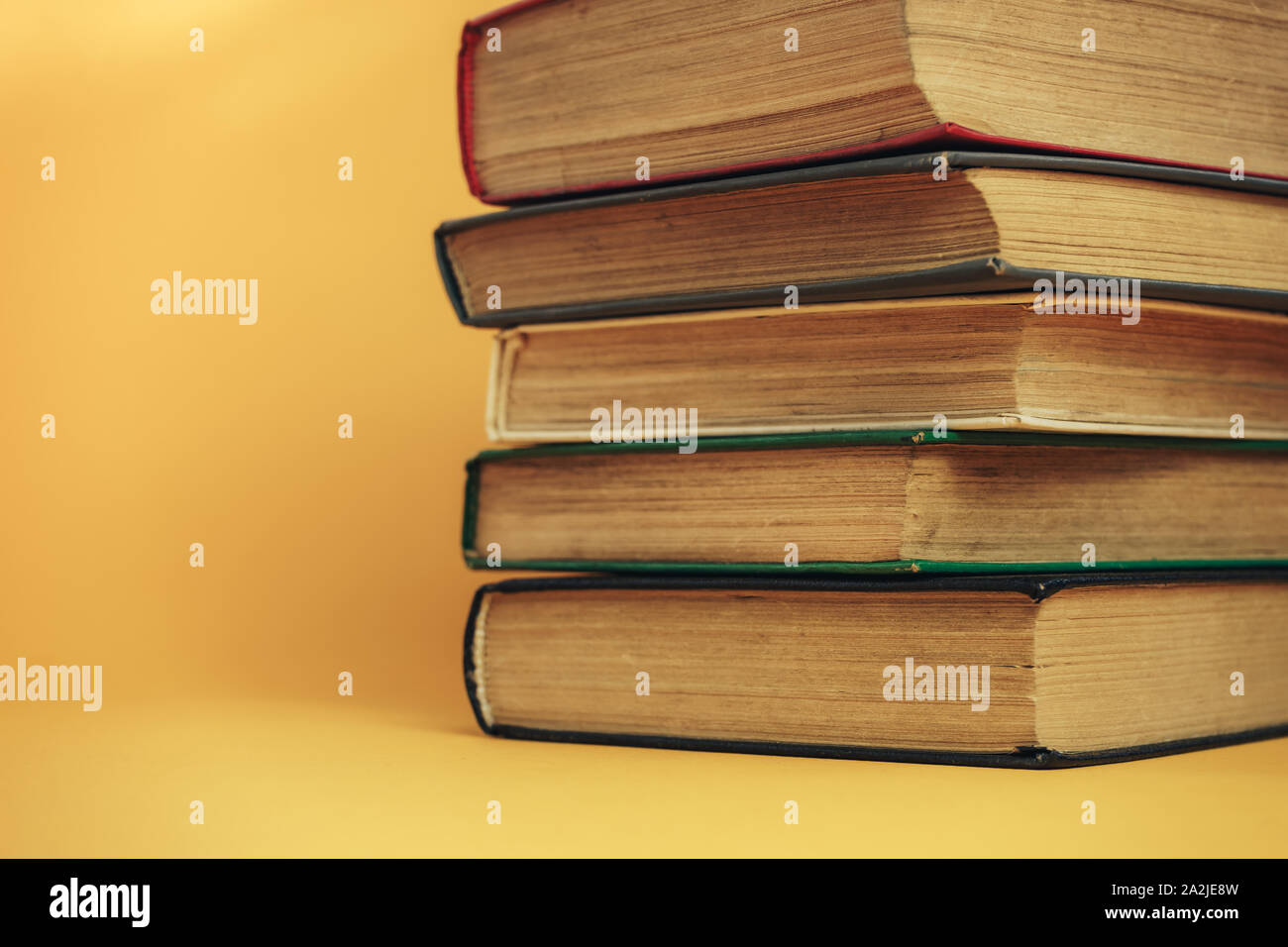 Beautiful old books on a orange background Stock Photo - Alamy
