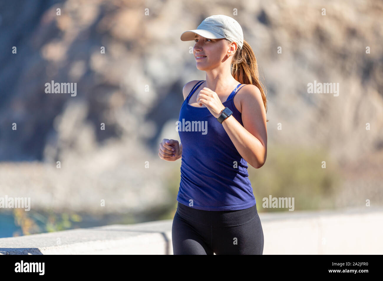 Slim woman in blue top running in the morning. Fitness girl jogging for ...