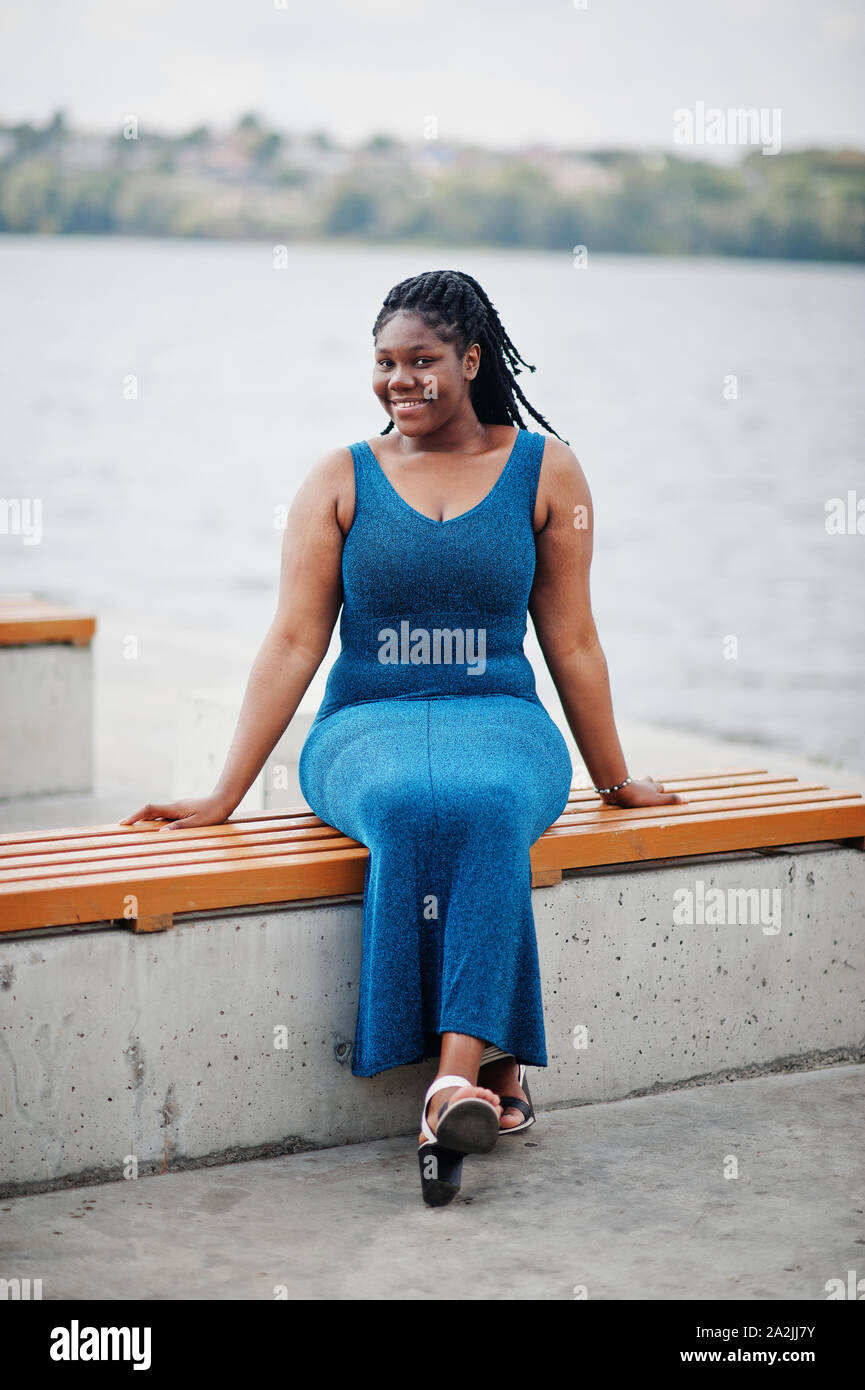 African american dark skinned plus size model posed in a blue shiny ...