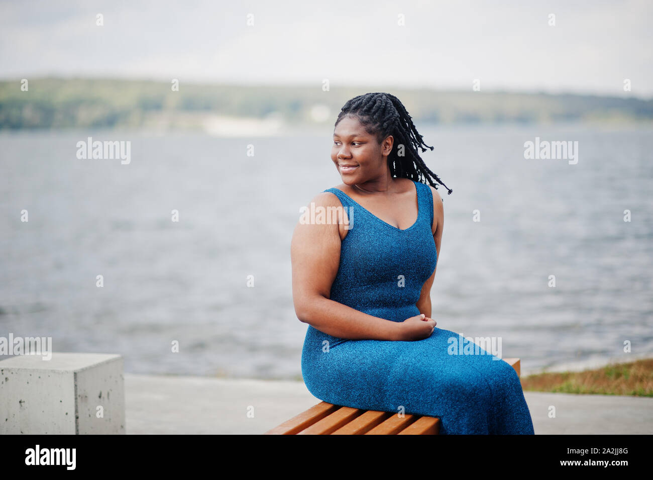 African american dark skinned plus size model posed in a blue shiny ...