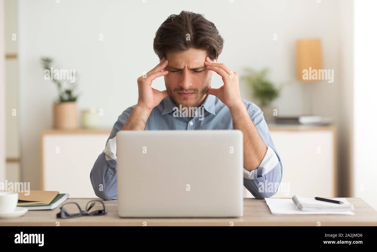 Millennial Guy Suffering From Headache Working On Laptop Indoor Stock ...