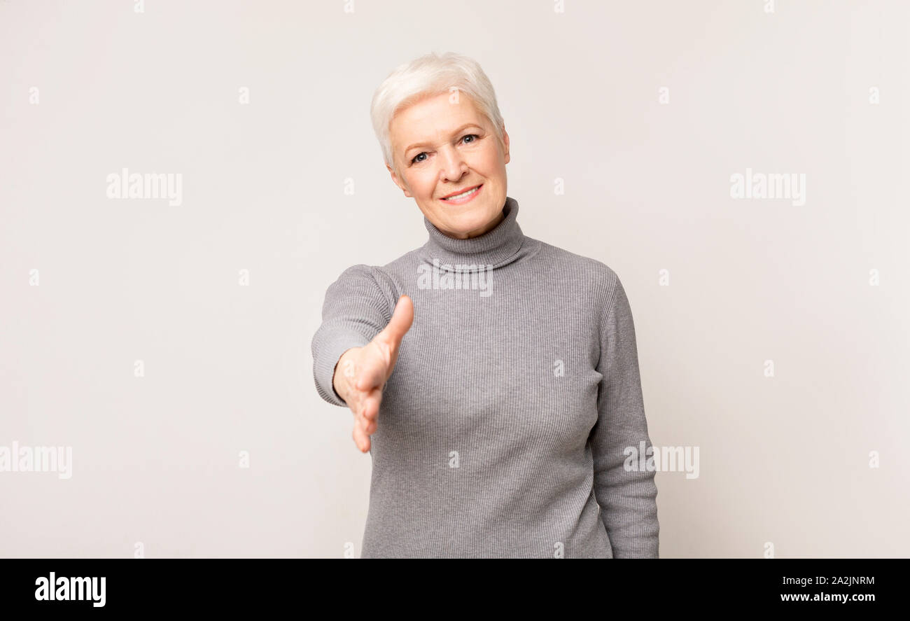 Elderly woman extending hand for handshake on camera Stock Photo - Alamy