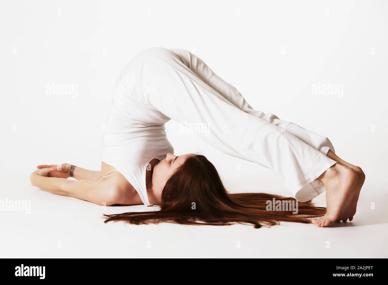 Woman in plough Yoga posture (Halasana Stock Photo - Alamy