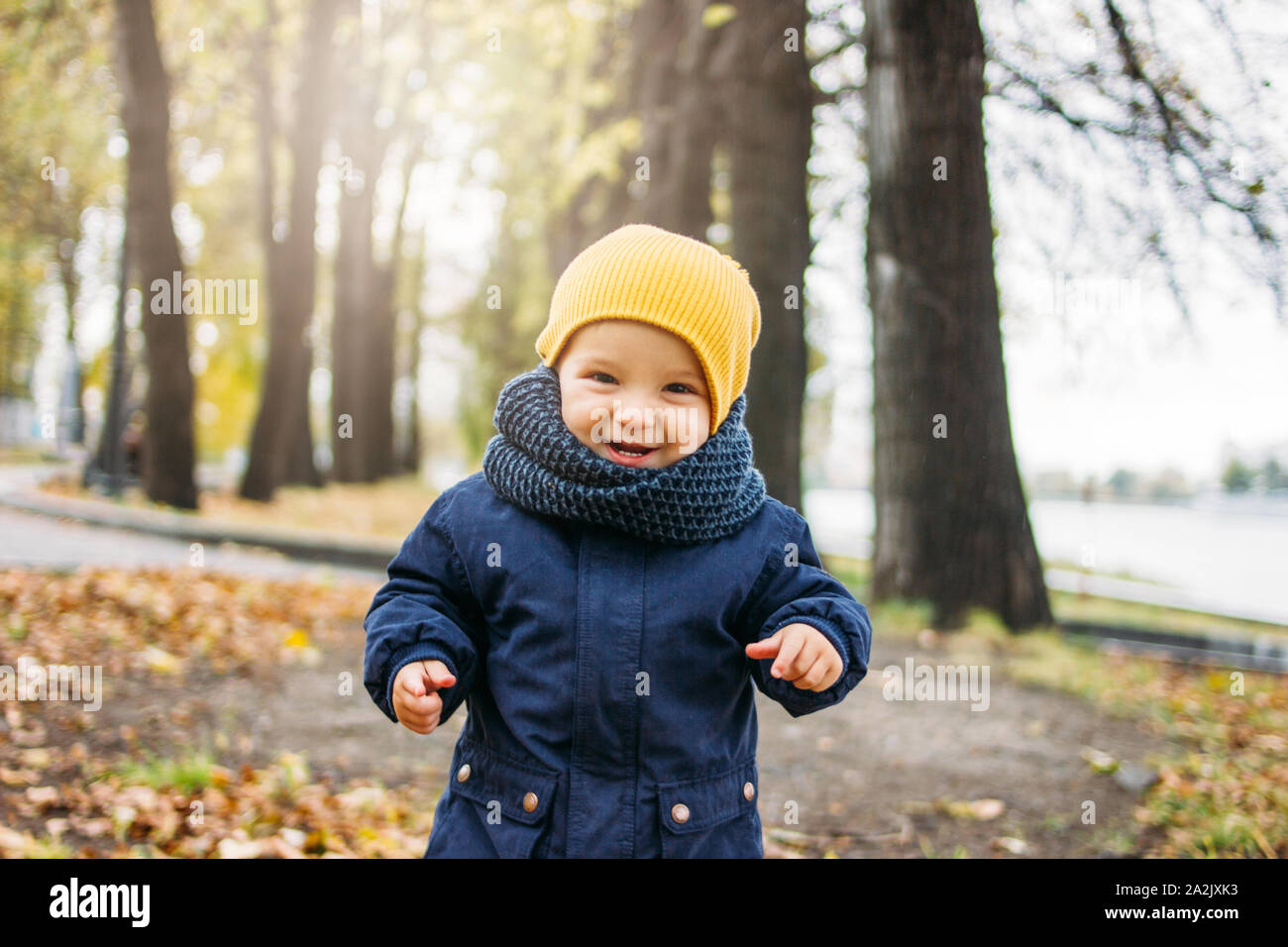Cute happy baby boy in fashionable casual clothes in the autumn nature ...