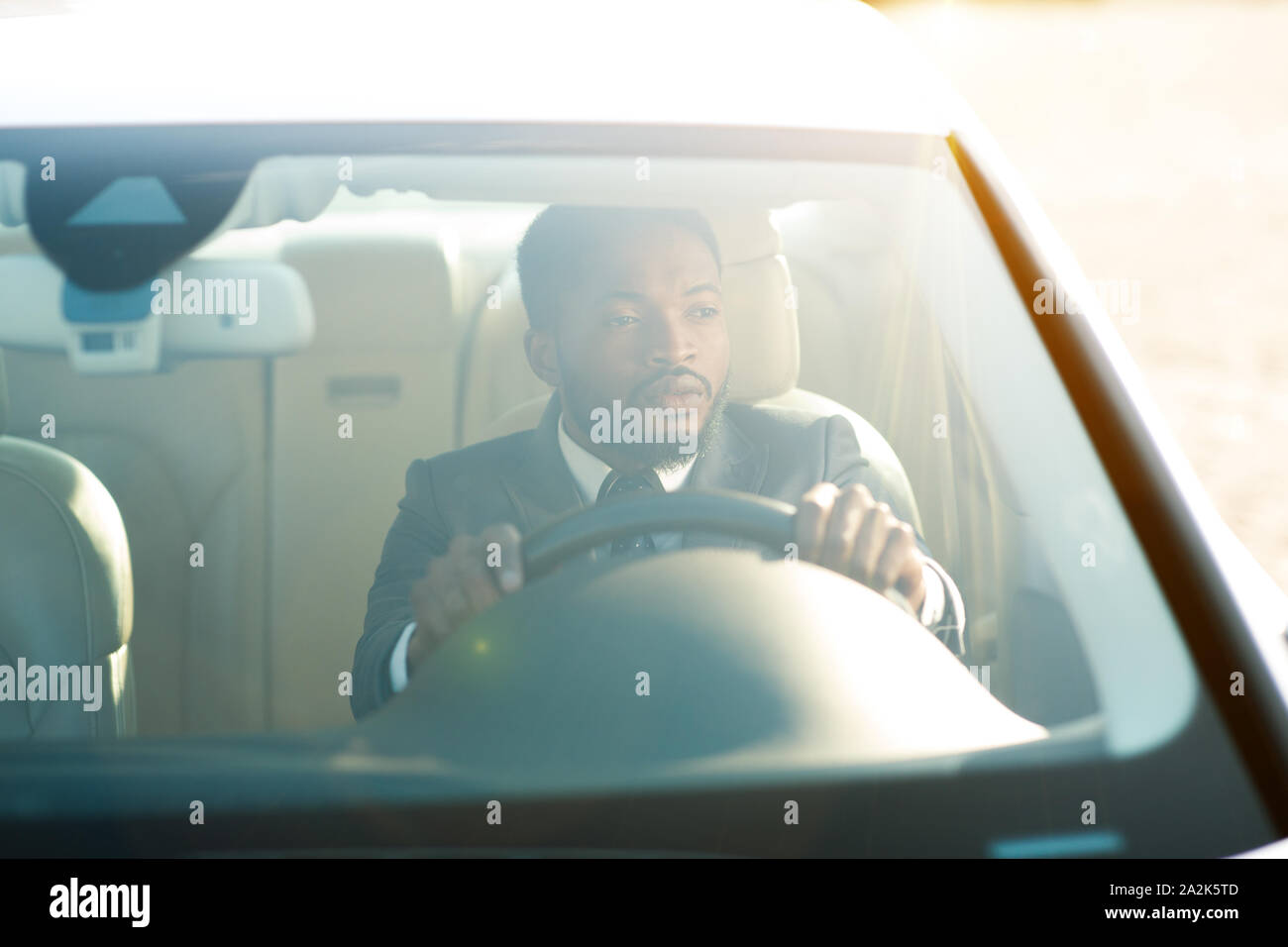 Serious businessman driving luxury car, view from windshield Stock ...