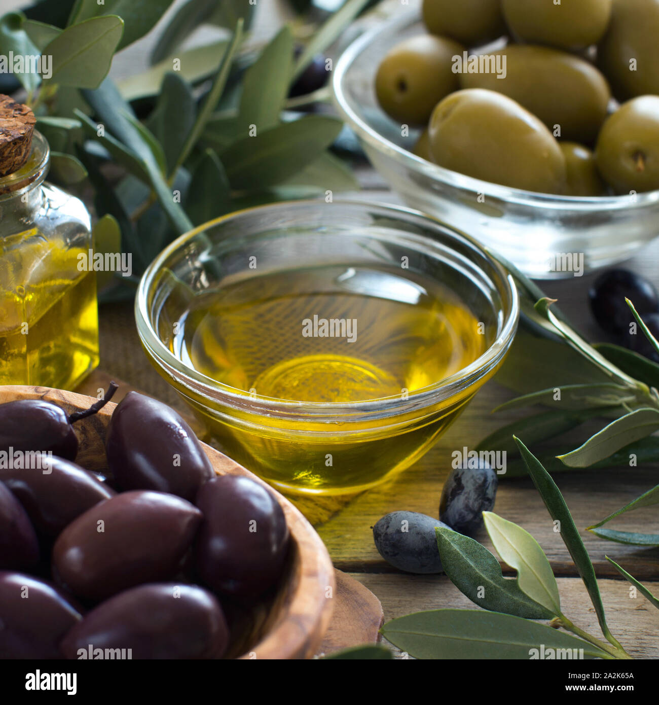Olive oil and olives on rustic wood background Stock Photo - Alamy