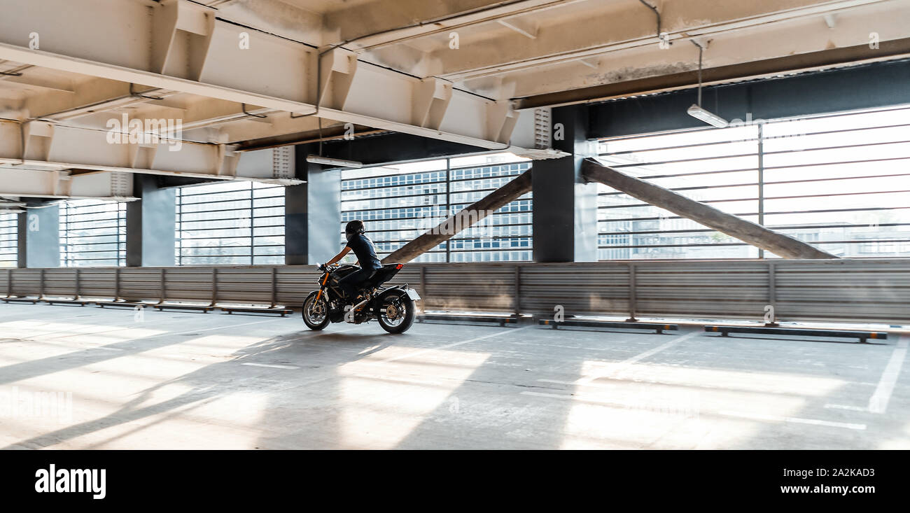 Distant plan of biker riding motorcycle at parking. Urban background ...