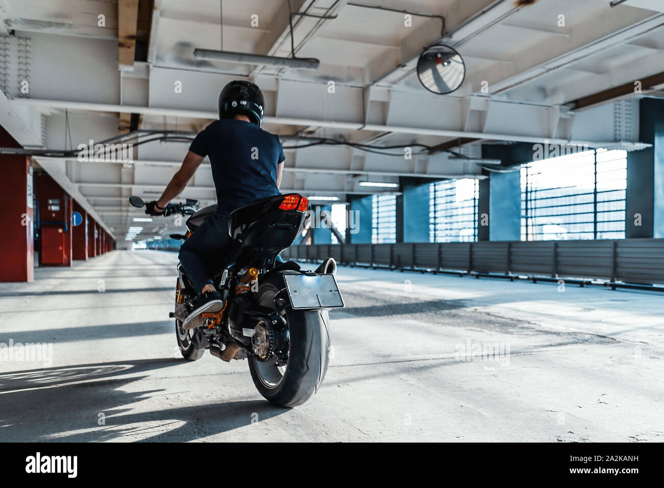 Distant plan of biker riding motorcycle at parking. Urban background ...