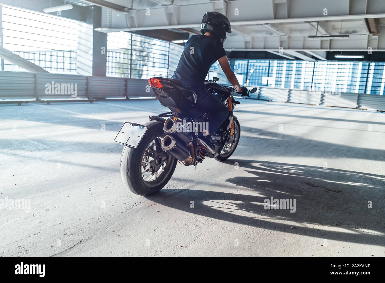 Distant plan of biker riding motorcycle at parking. Urban background ...
