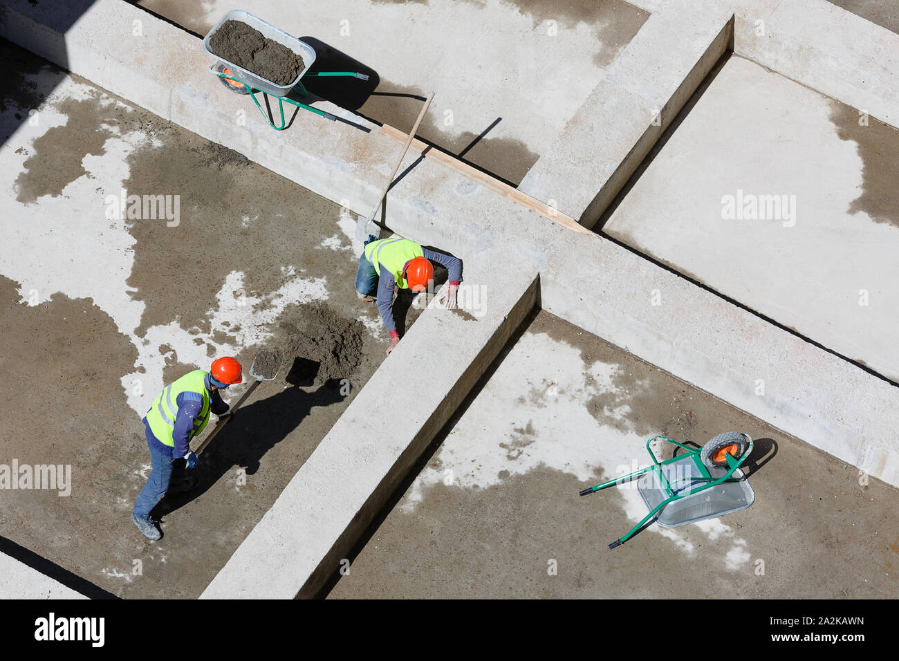 Uniformed workers clean sand on a construction site, top view Stock ...