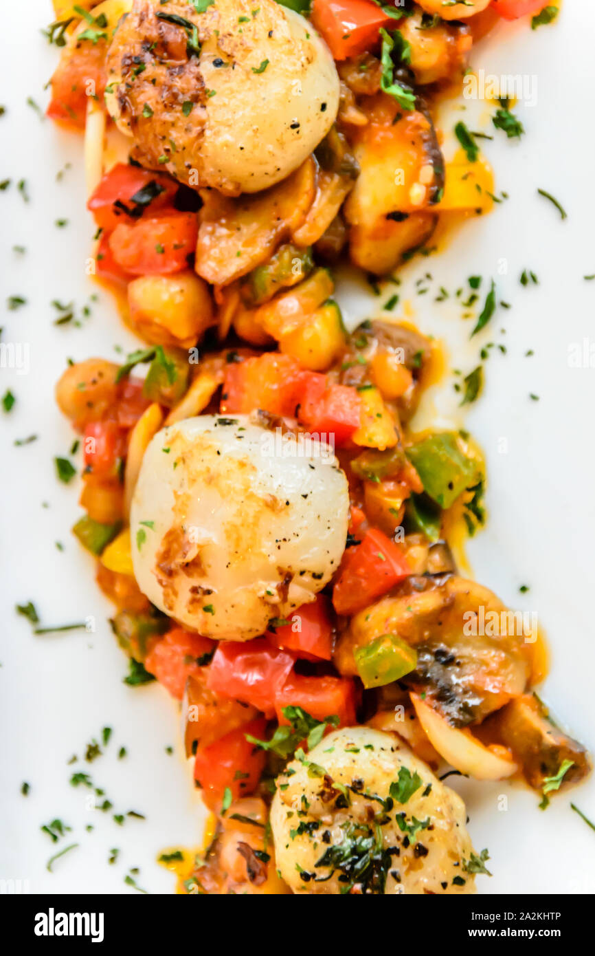 starter of seared scallops with tomato and zuchini salsa with herb and ...