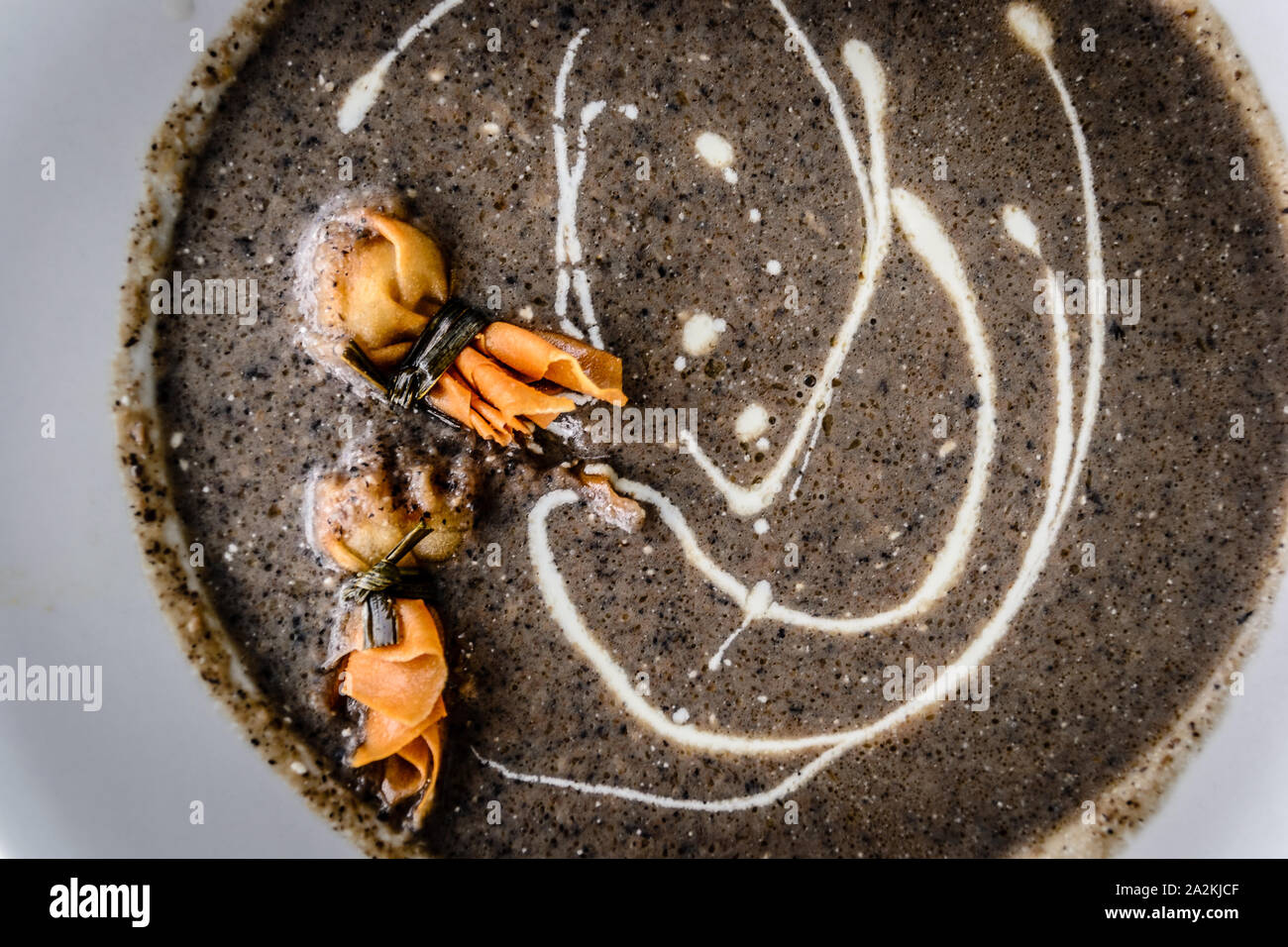 cream of mushroom soup served in a white china dish and topped with 2 ...