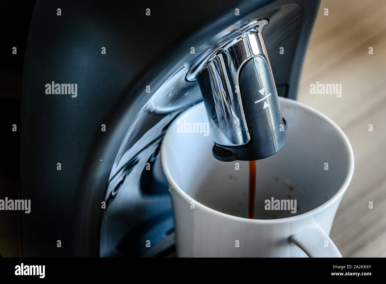 espresso coffee maker machine making and flowing out espresso into a ...