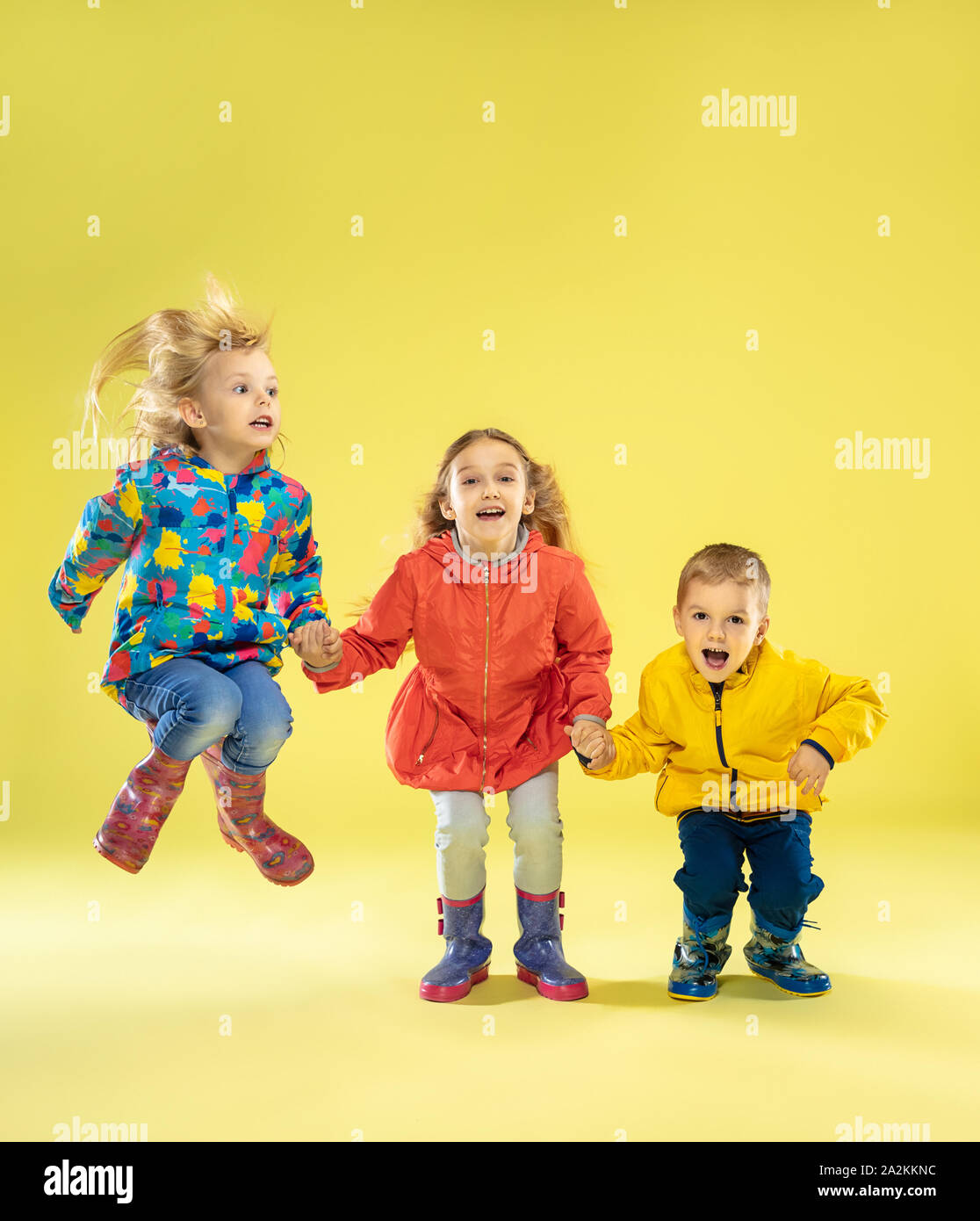 A full length portrait of a bright fashionable kids in a raincoat ...