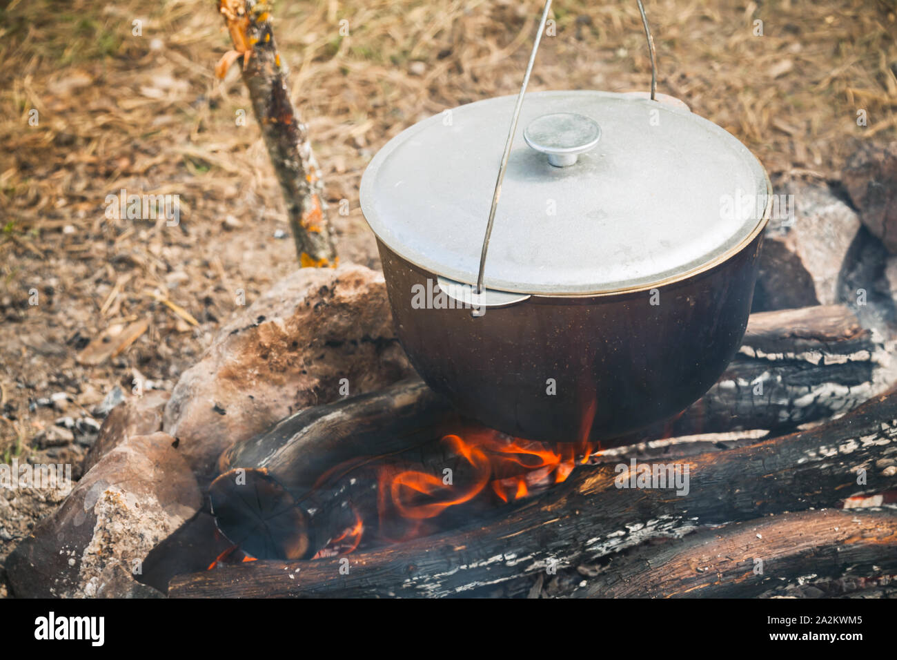 Closed cauldron boiling on a campfire. Camping meal Stock Photo - Alamy