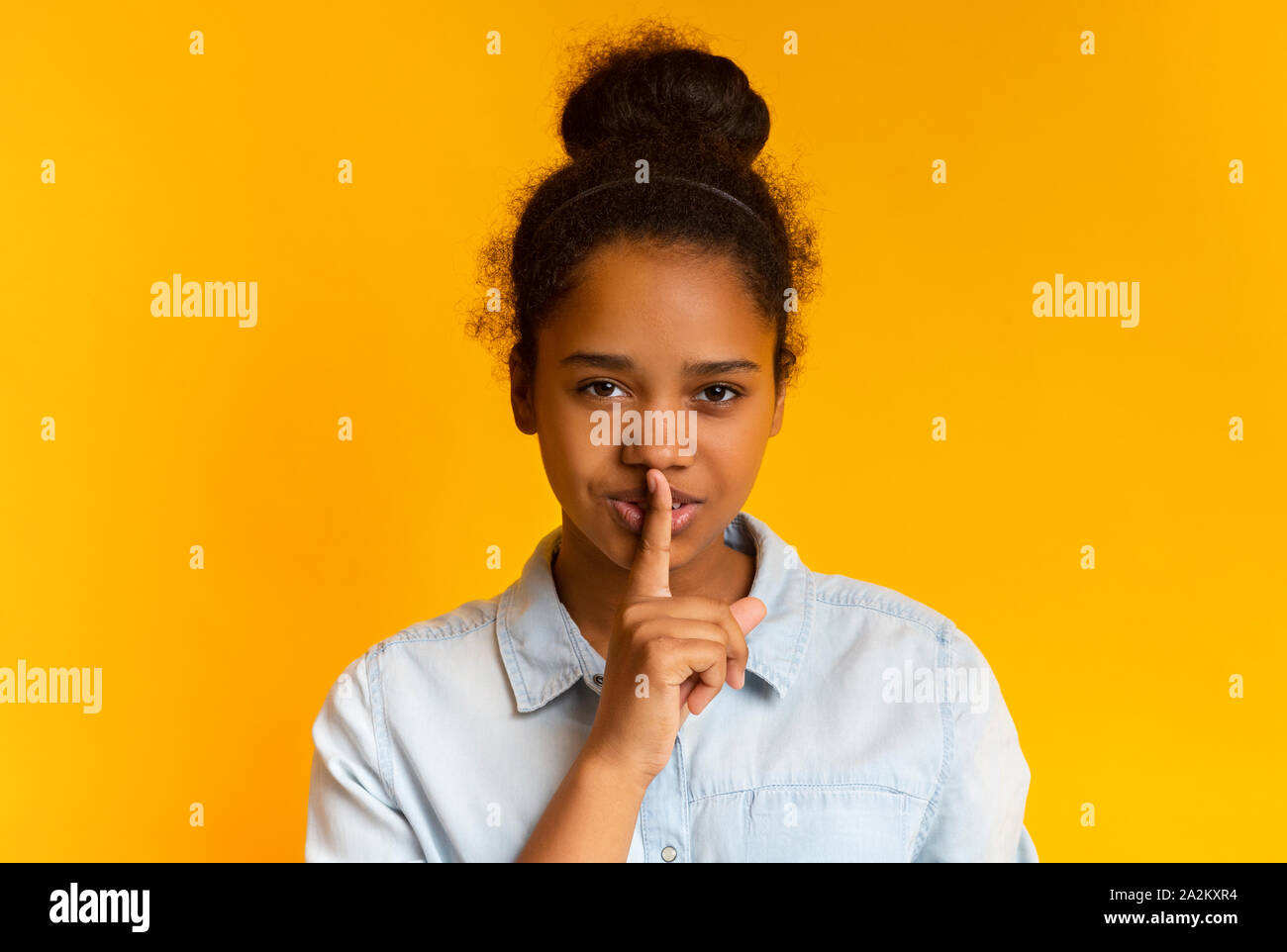 Beautiful black girl put finger on lips, making hush sign Stock Photo ...