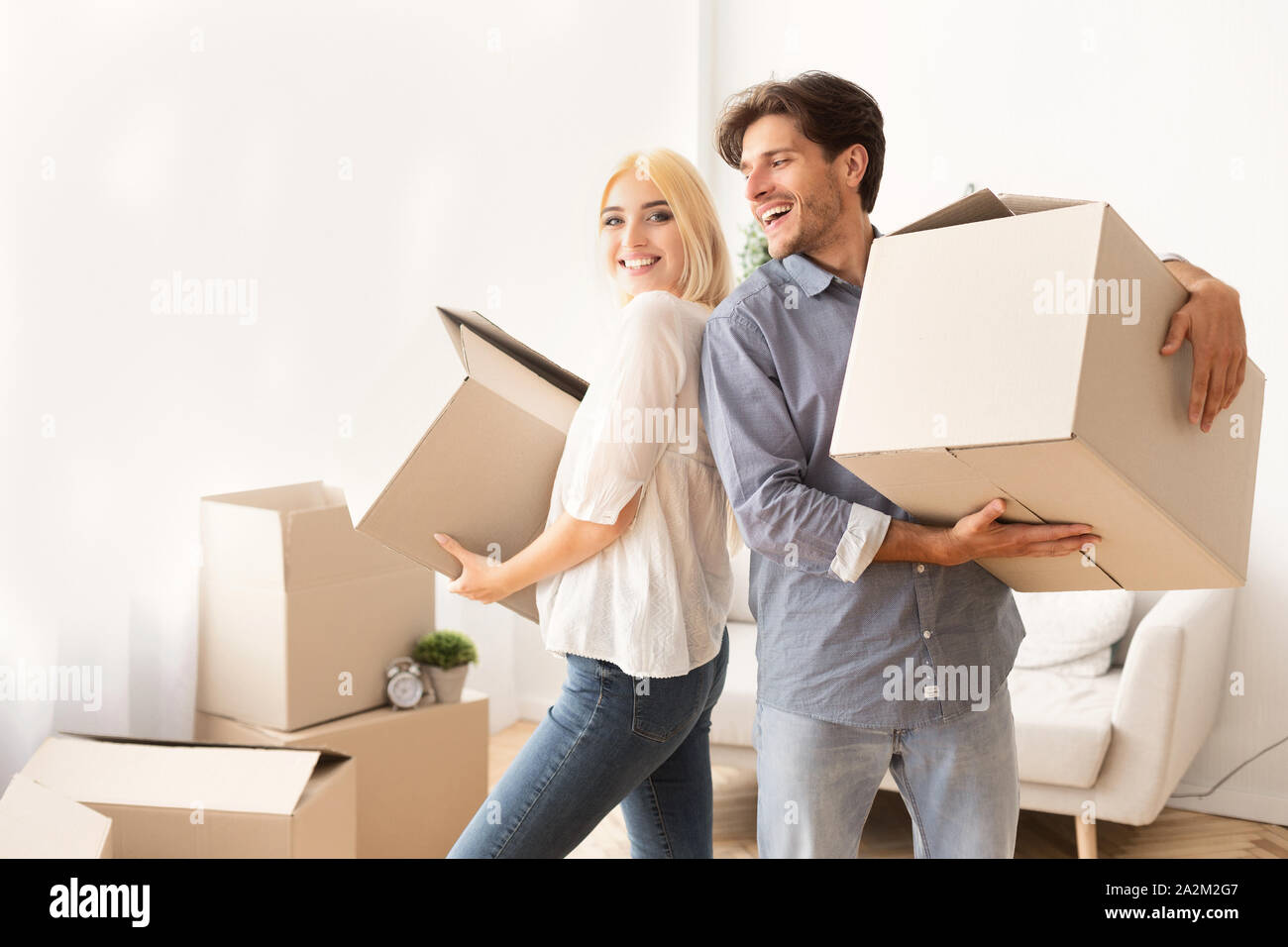 Happy Spouses Holding Moving Boxes Standing In New House Stock Photo ...