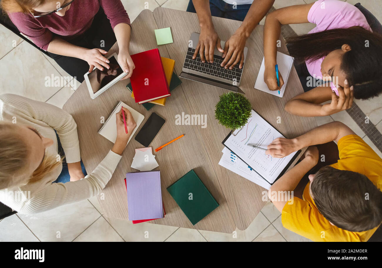 Group of international students sitting at table, top view Stock Photo ...