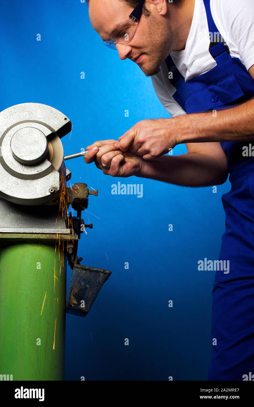 Worker on grinding bench Stock Photo - Alamy