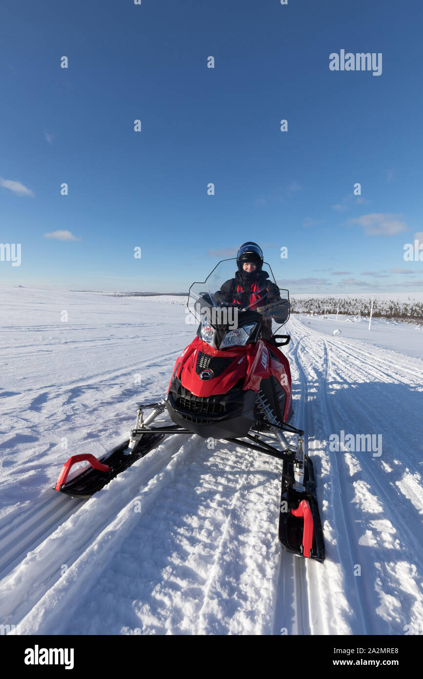 Woman driving snowmobile at arctic winter wonderland Lapland Stock ...