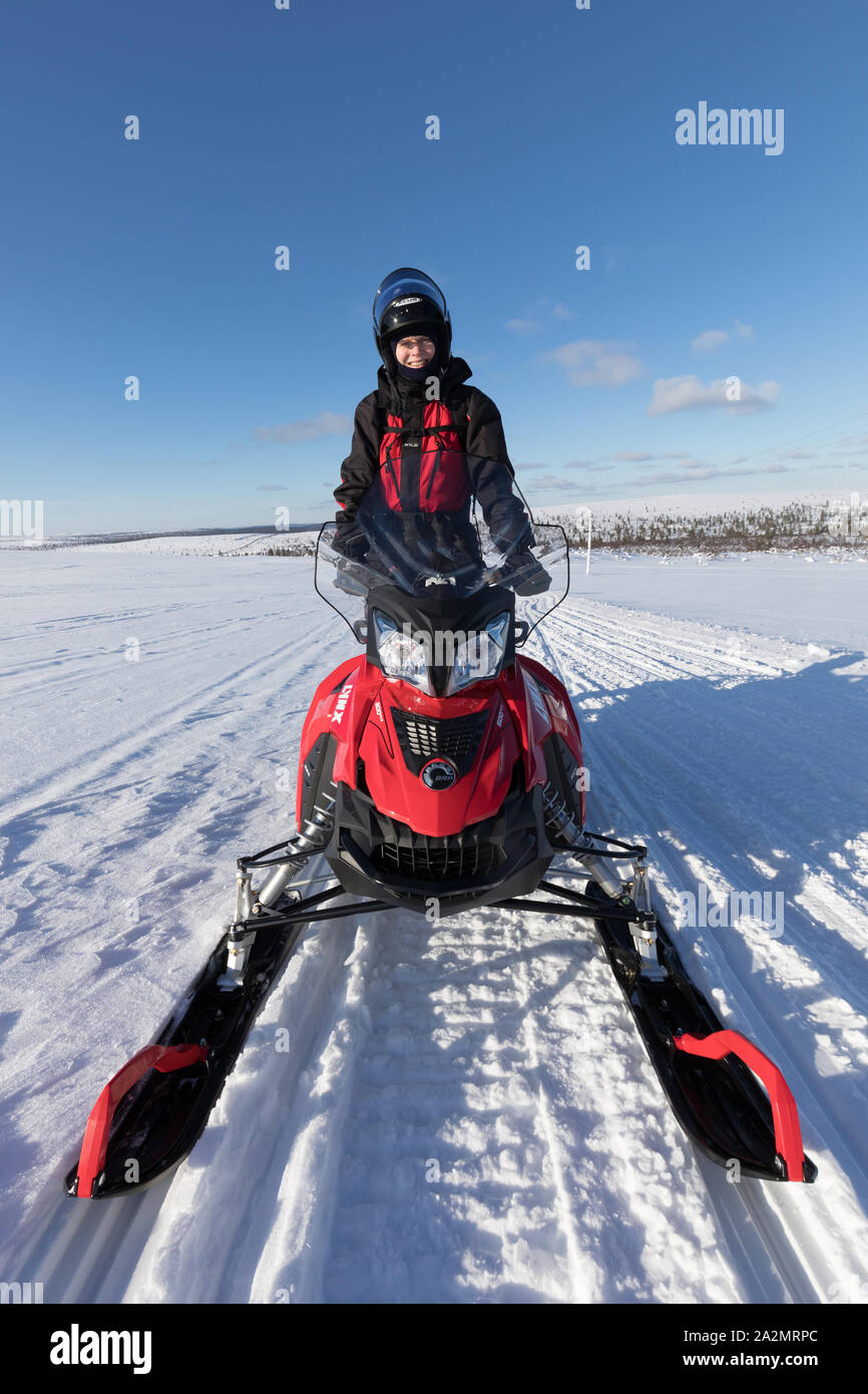 Woman driving snowmobile at arctic winter wonderland Lapland Stock ...