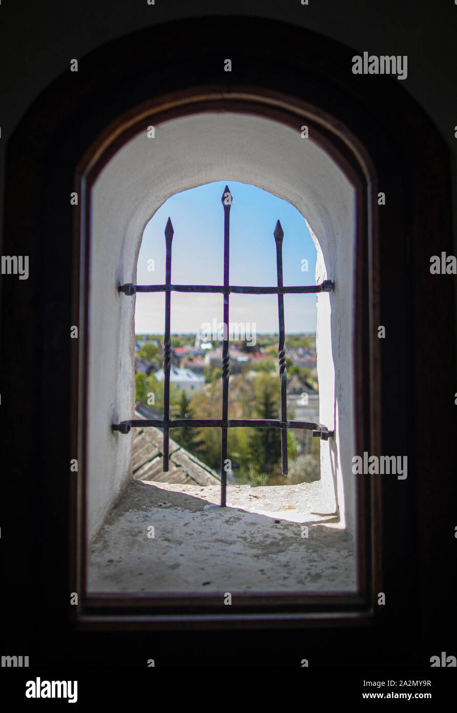 View of the city through the old arch window Stock Photo - Alamy