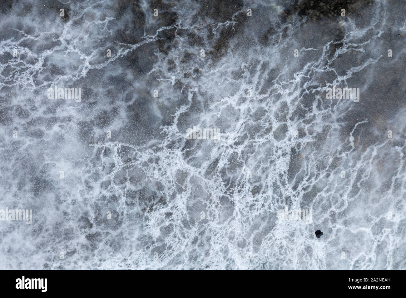 A sheet of ice coating a rock cracking with veins along the Piermont ...