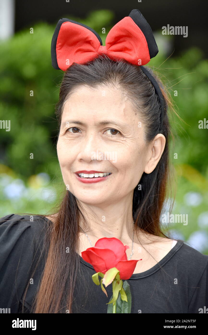 Old Filipina Female Senior Smiling With A Flower Stock Photo - Alamy