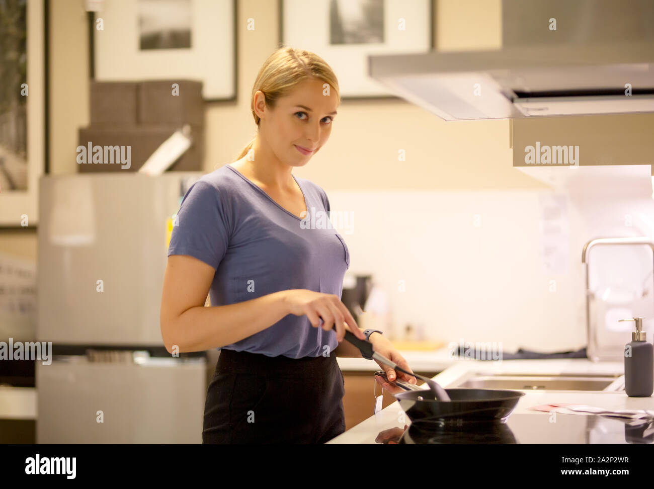 Side view portrait of women in her cooking dinner standing by stove and ...