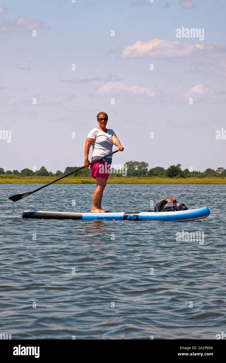 woman standing on paddle board, water sport; skill, Sinepuxent Bay ...