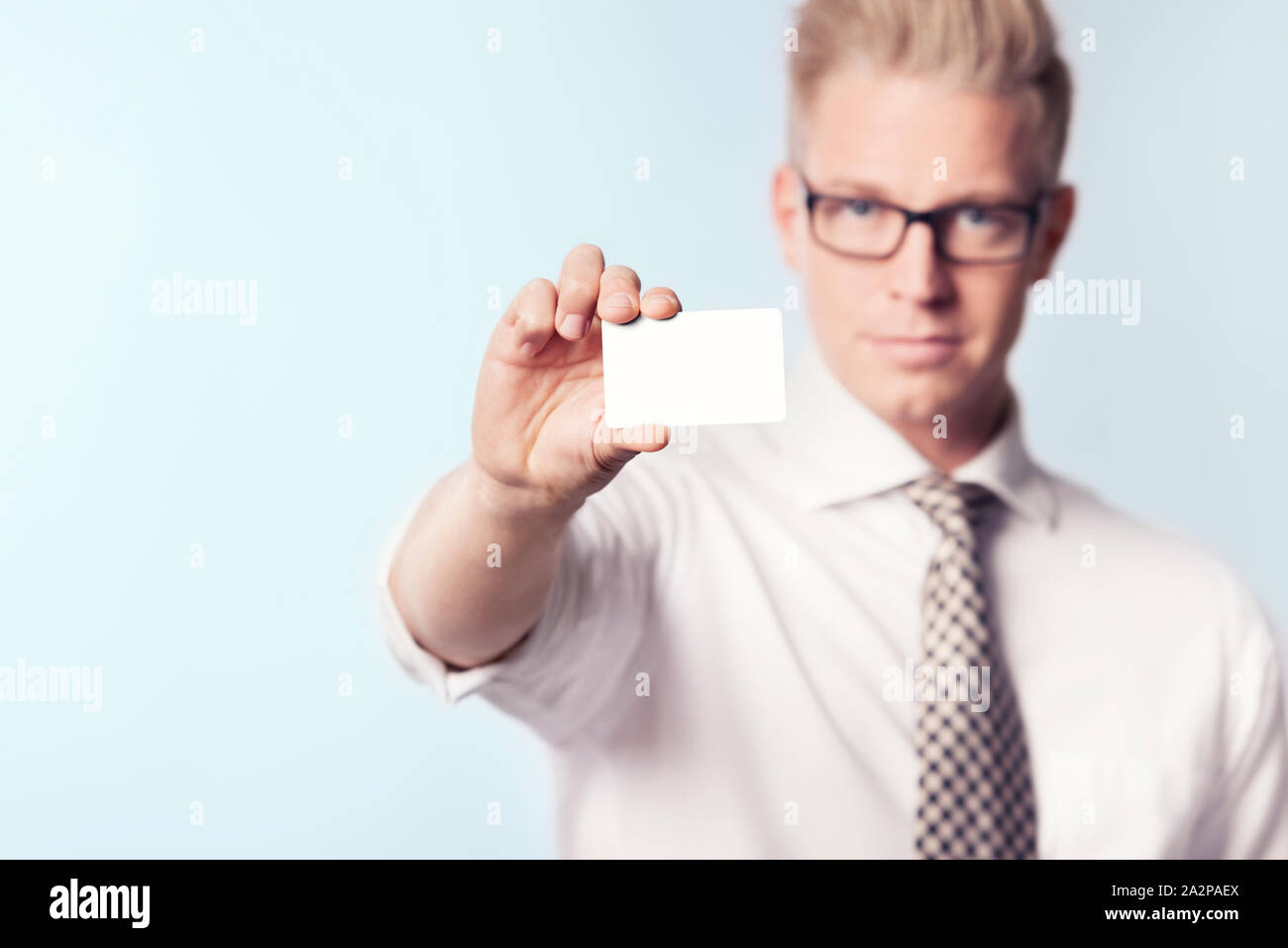 Likable businessman showing white blank card Stock Photo - Alamy