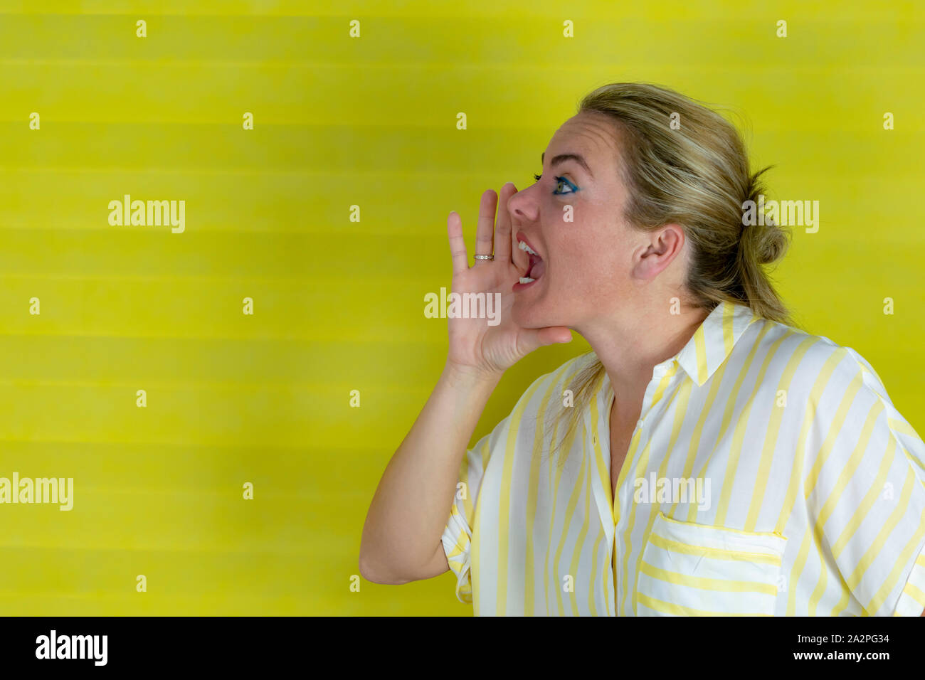 Young woman over isolated background shouting loud to side with hand on ...