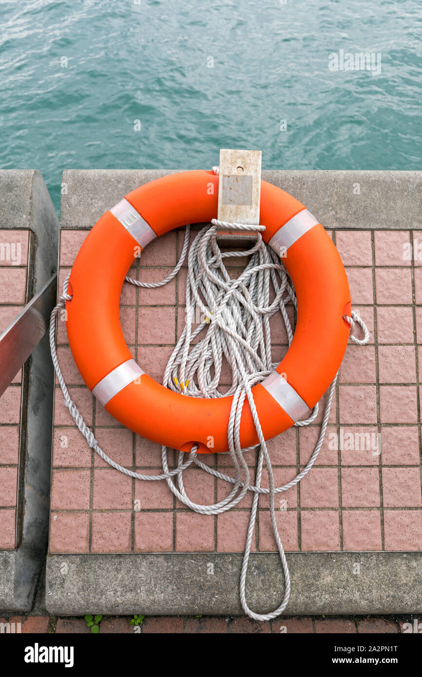 Life Preserver Lifebuoy With Rope at Sea Wall Stock Photo - Alamy
