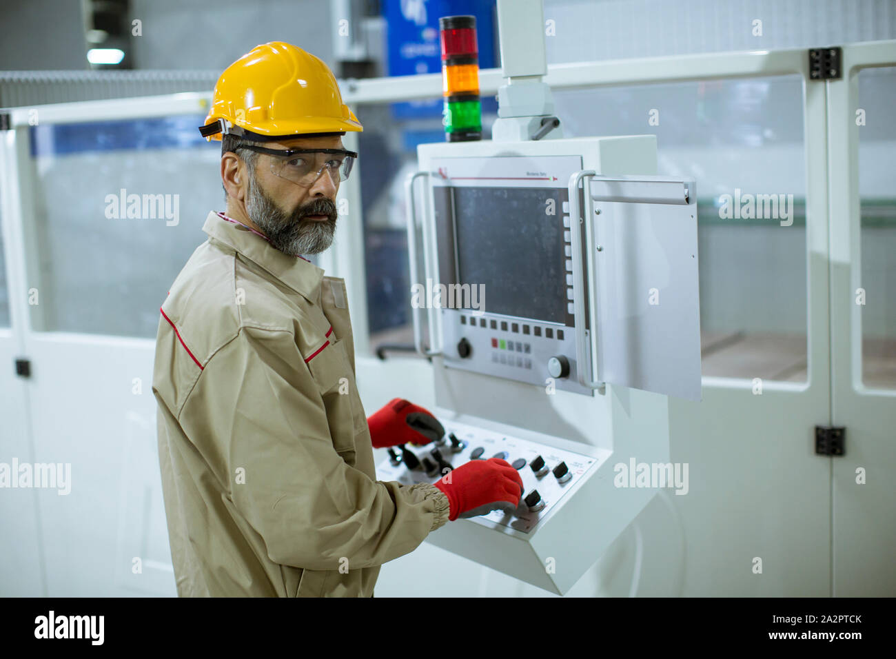 Portrait of senior man operating machine units in modern wooden factory ...