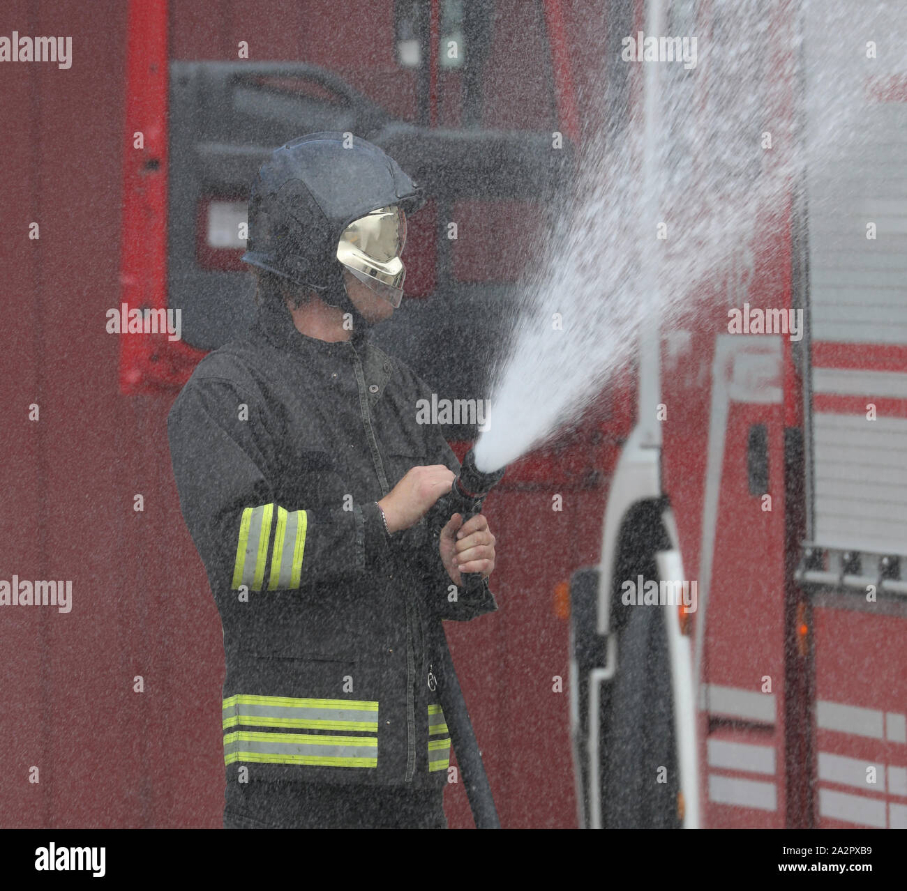 firefighter during the drill with hose hydrant Stock Photo - Alamy
