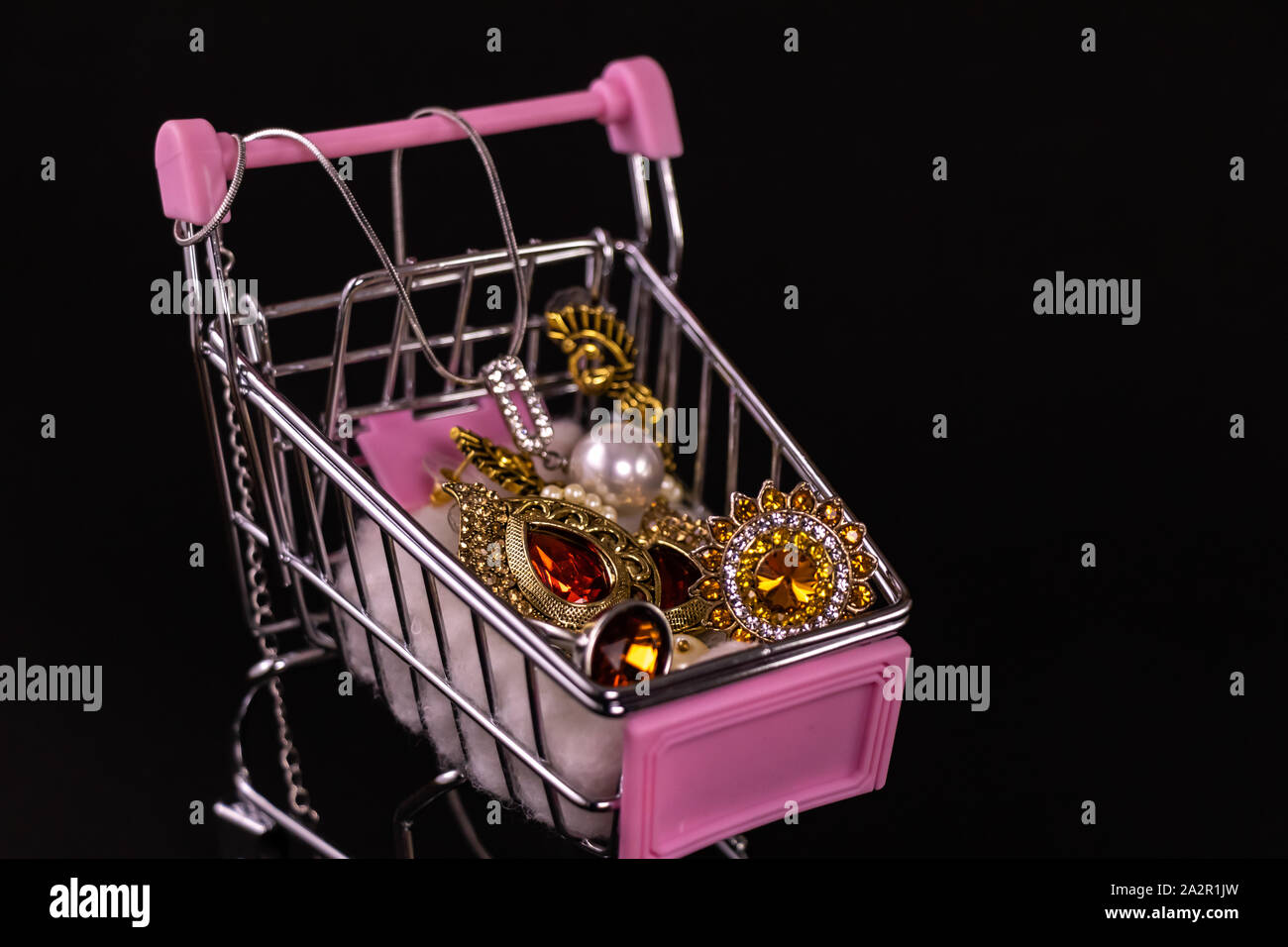 Jewellery shopping concept. Mini shopping cart full of beautiful ...