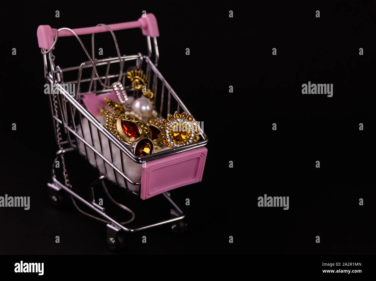Jewellery shopping concept. Mini shopping cart full of beautiful ...