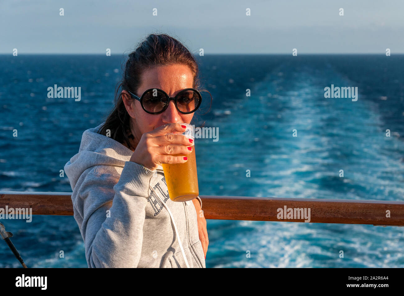 Girl drinking beer on a cruise ship deck with with sea background Stock ...