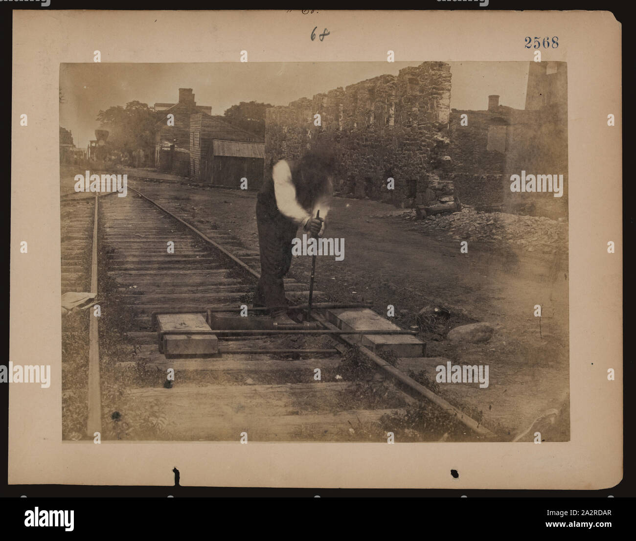 Railroad construction worker straightening track Stock Photo - Alamy