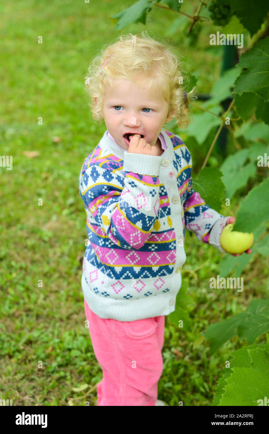blond girl eatign a raspberry Stock Photo - Alamy