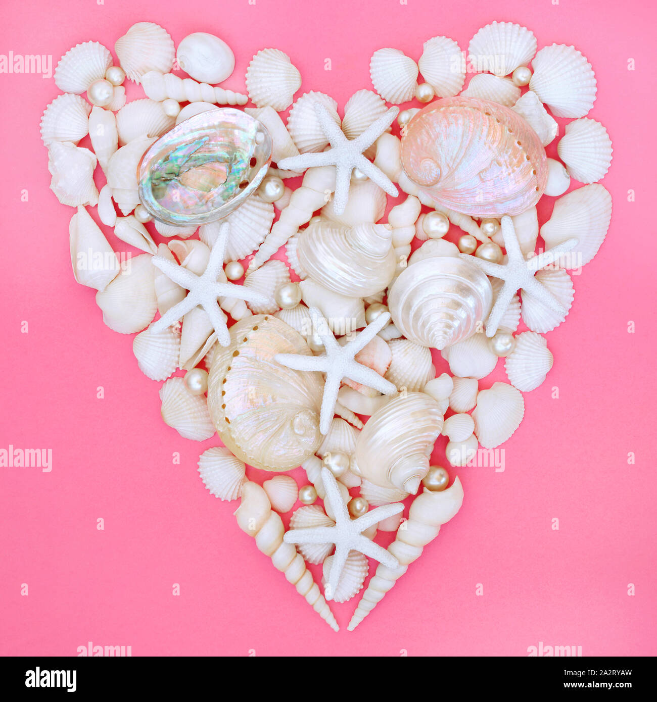 Seashell, starfish and pearl heart with a variety of white shells on ...